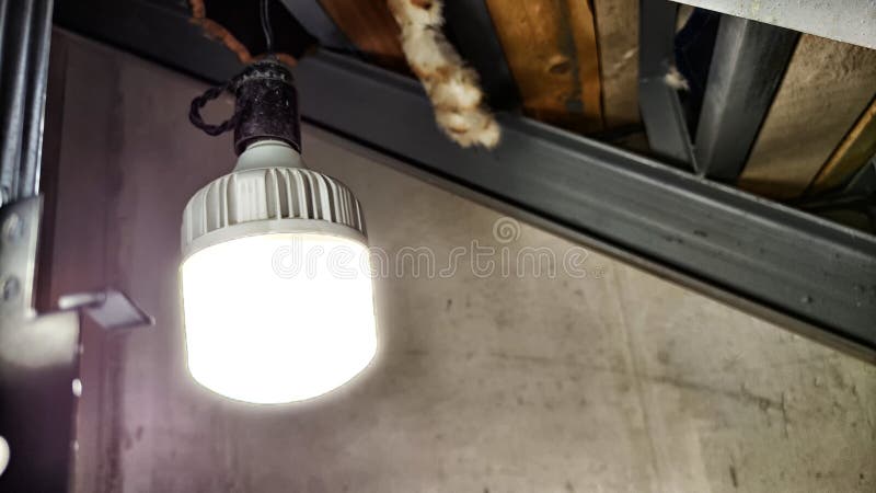 LED Bulb Illuminating a Dark Technical Room at Night. an LED Light Bulb ...