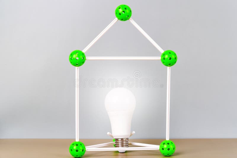 LED Light Bulb is Placed Inside a Simple House Frame Structure Stock ...