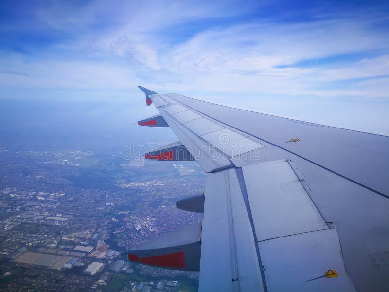 A Left Aircraft Wing Flying on the Sky Above the City. Stock Image ...