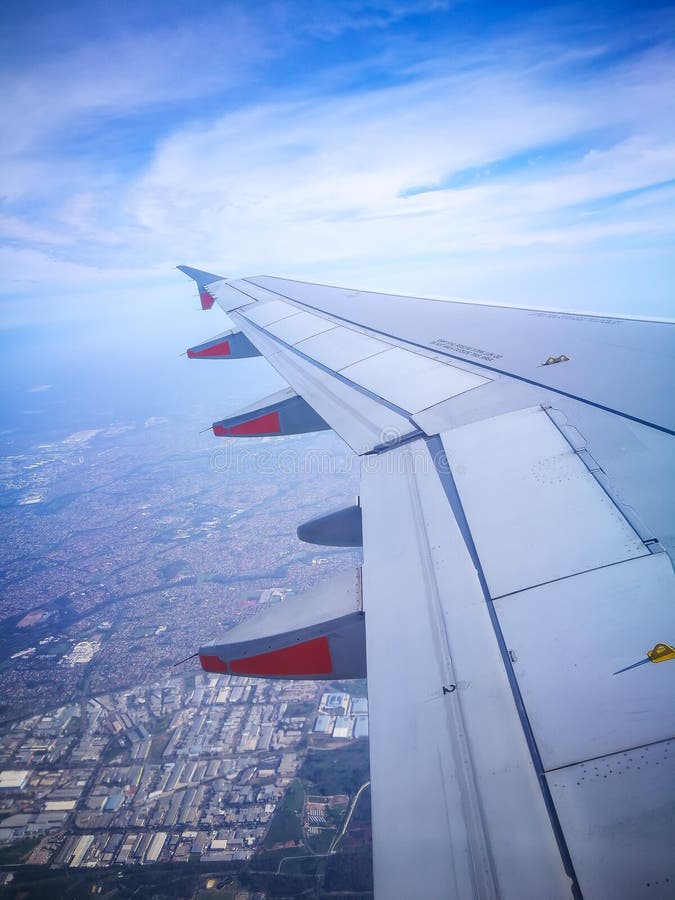 A Left Aircraft Wing Flying on the Sky Above the City. Stock Image ...