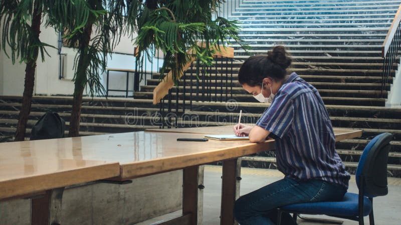 Left Angle Young College Student Taking Notes in the Library Alone ...