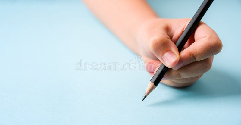 Left Hand Holding a Ballpoint Pen on an Open Notebook on a Blue ...