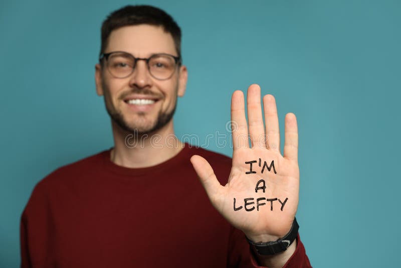 Left-handed Man Against Light Blue Background, Focus on Palm with Text ...
