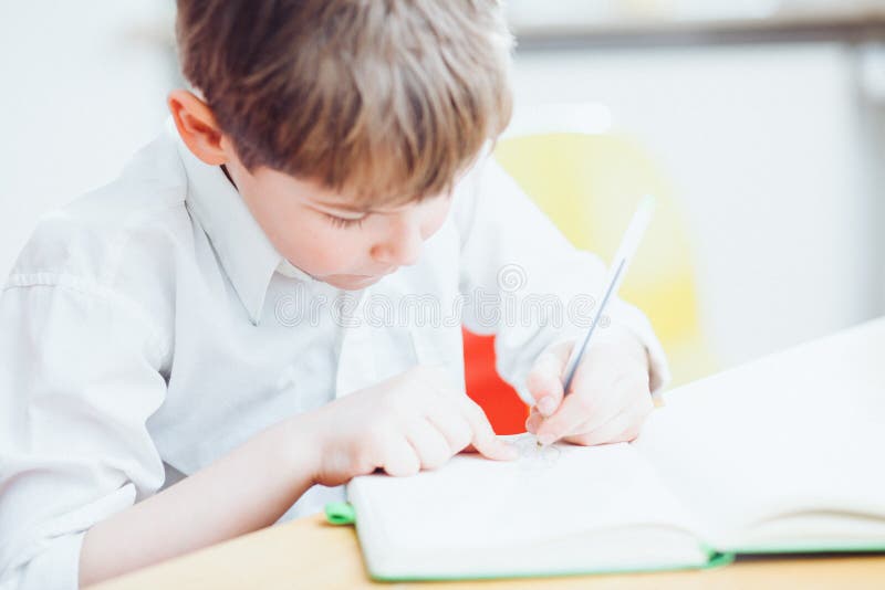 Left Handed School Boy Writing or Drawing in Book Stock Photo - Image ...
