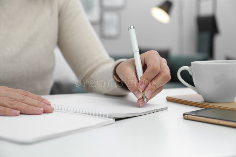 Left-handed Woman Writing in Notebook at Table Indoors, Closeup Stock ...
