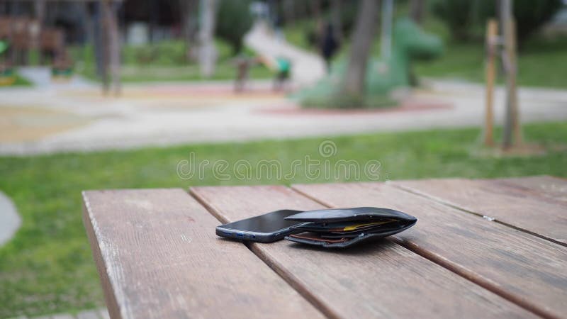 Left Wallet and Smart Phone on a Bench in the Park Stock Video - Video ...