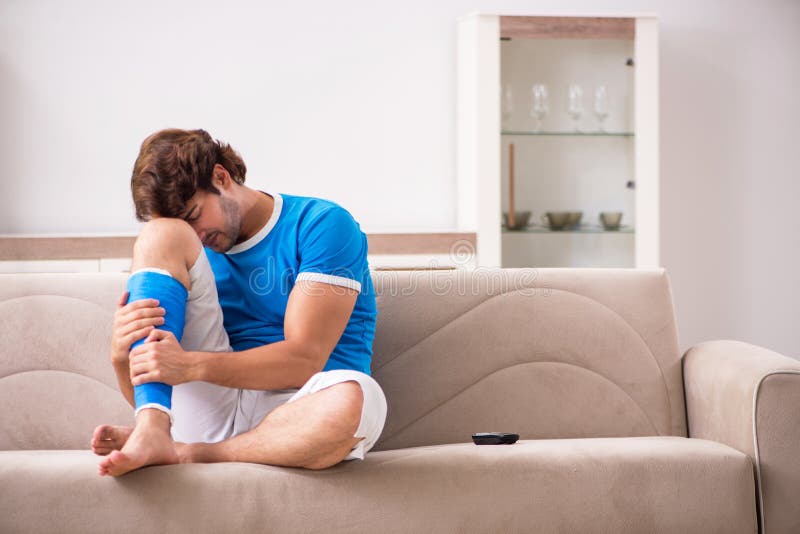 The Leg Injured Young Man on the Sofa Stock Photo - Image of bandaging ...