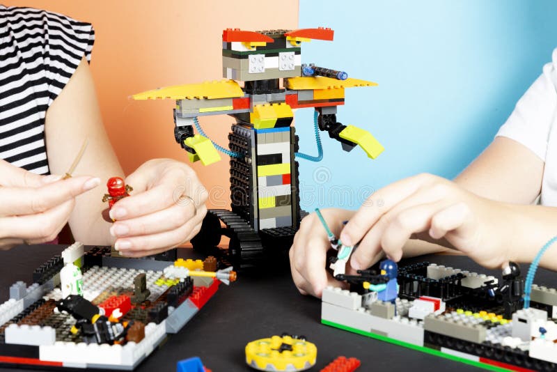 Lego Robot. a Child and a Woman Assemble a Robot from Plastic Parts ...
