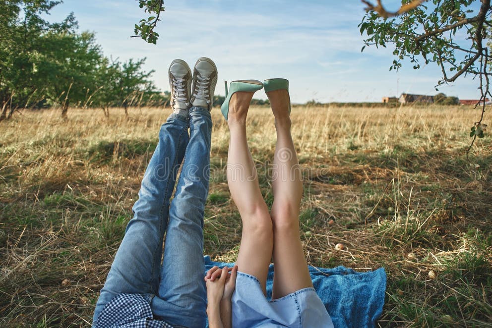 Legs of a Couple Lying on the Grass in the Apple Orchard Stock Photo ...