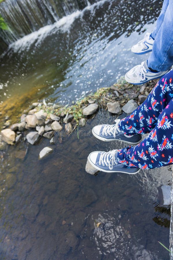 Legs Dangle Over the Edge of a River Stock Photo - Image of park ...