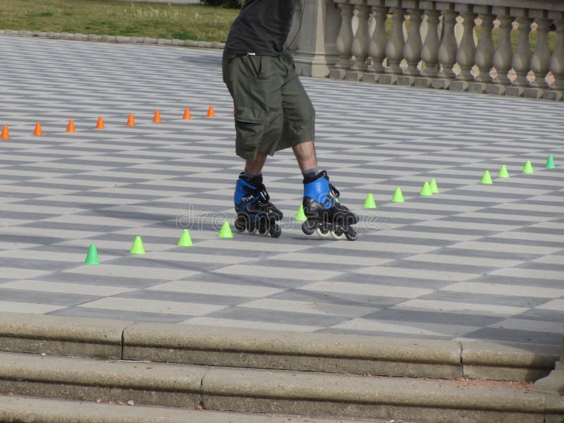 Legs of Guy on Rollerblades. Rollerblader and Slalom Cones Stock Image ...
