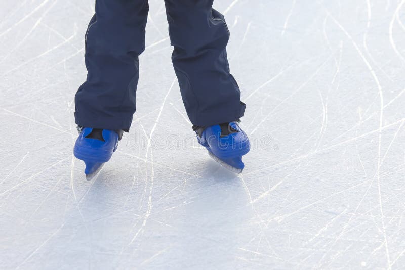 Legs of a Man in Blue Skates Rides on an Ice Rink Stock Image - Image ...