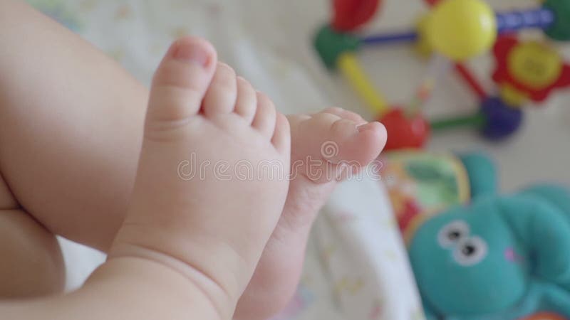 The Legs of a Newborn Baby are Happily Tapping on the Bed. the Child is ...