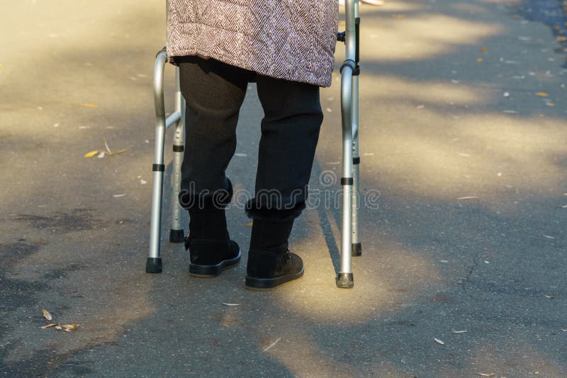 The Legs of an Old Man Walking with the Help of a Walker Made of ...