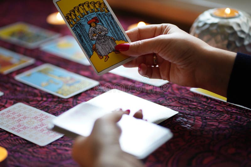 Leitor De Tarô Pegando Cartões De Tarô Perto De Velas Queimadas Foto