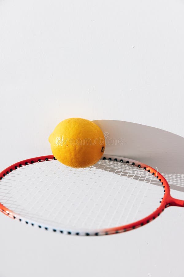 Lemon and Badminton Racket Casting a Shadow on a White Surface Stock ...