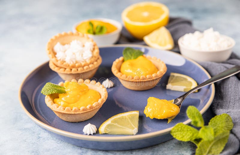 Lemon Curd Mini Tarts Decorated with Mint and Lemon Slices on Blue ...