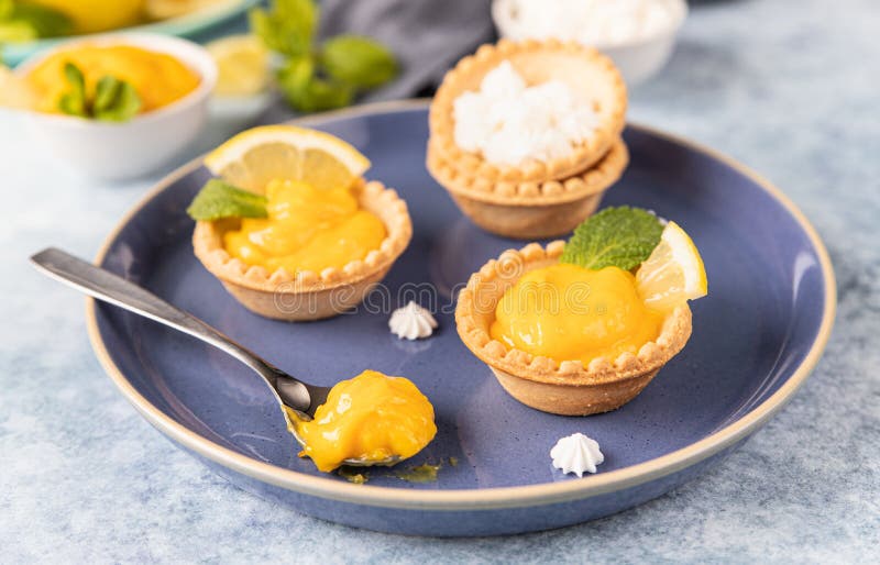 Lemon Curd Mini Tarts Decorated with Mint and Lemon Slices on Blue ...