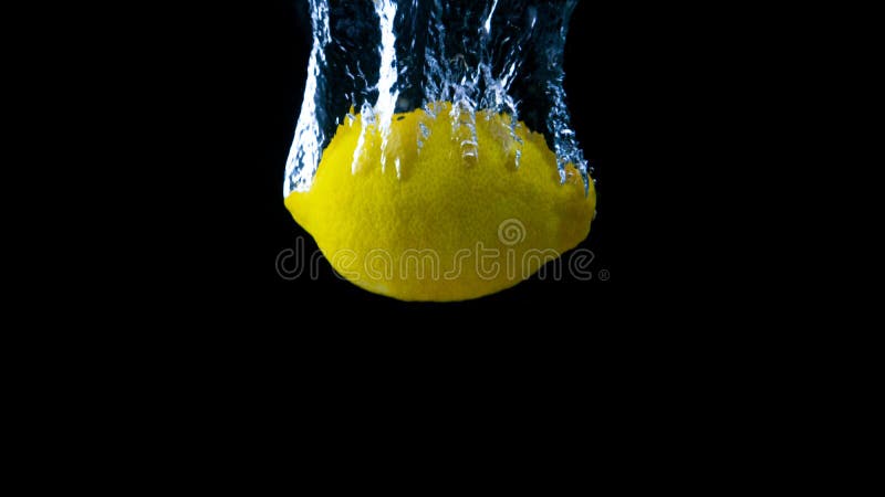 Lemon Drops into Water with Water Bubbles on Black Background Stock ...