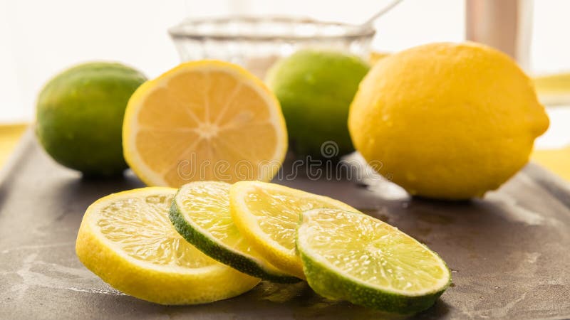 Lemon and Lime Slices in Front of Whole Fruit Stock Image - Image of ...