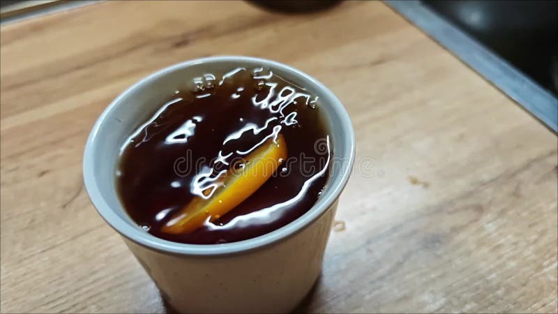 Lemon Slice Falling and Floating in a Tea Cup Stock Footage - Video of ...