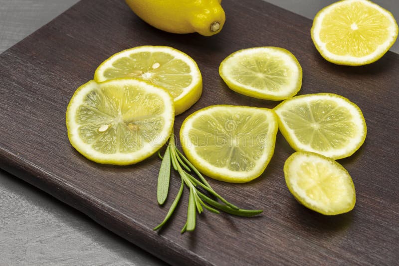 Lemon Slices on Cutting Board. Sprig of Rosemary Stock Photo - Image of ...