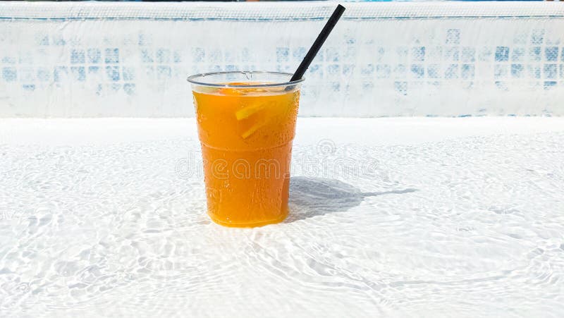 Lemonade with Orange and Lemon in a Glass with a Straw by the Pool in ...