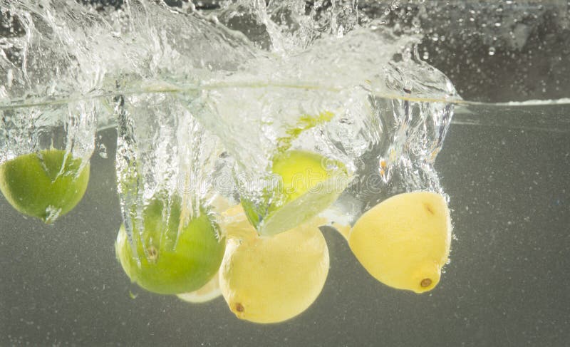 Lemons and Limes Making a Splash Stock Photo - Image of clear, water ...