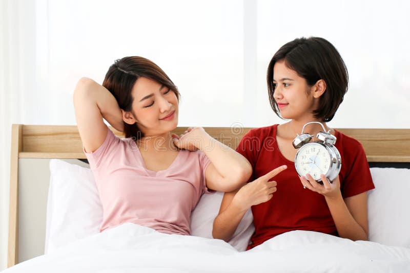 Lesbian Happy Couple Waking Up In Morning With Alarm Clock Having A