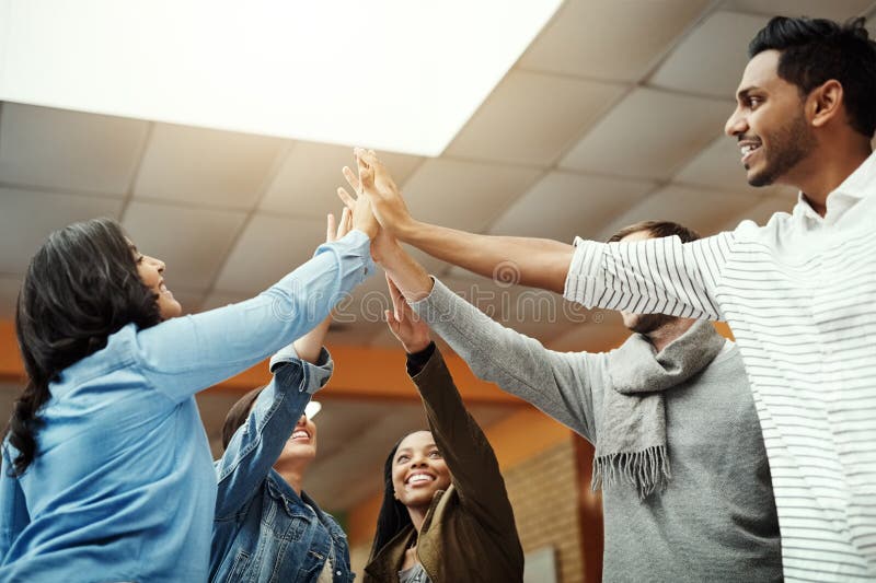Lets Do this. a Group of University Students High Fiving while Studying ...