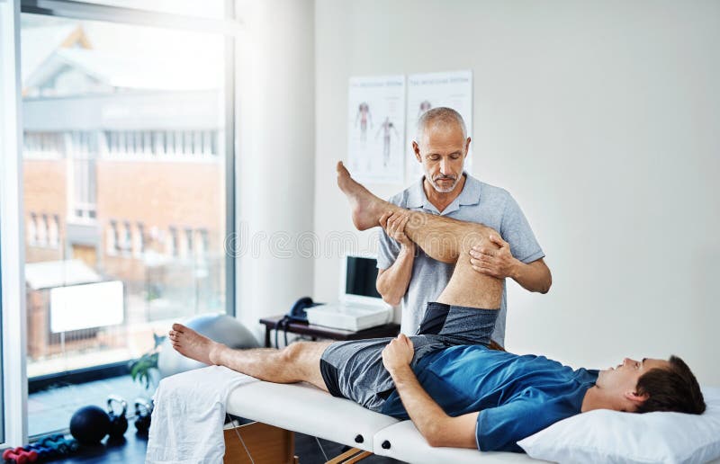 Lets Get this Leg Healed. Shot of a Physiotherapist Treating a Patient ...