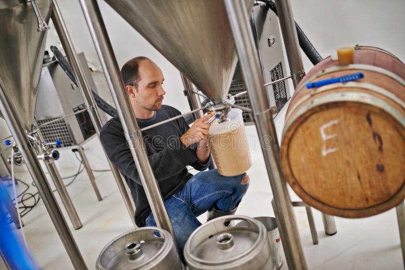 Lets Give this Batch a Test. a Man Working in a Microbrewery. Stock ...