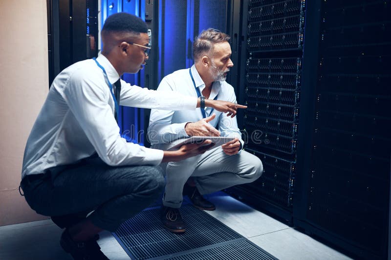 Lets Try Rewiring this One. Two Technicians Using a Digital Tablet while Working in a Server ...