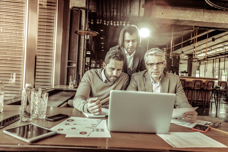 Group of Serious Partners Working Together at Their Project Stock Image ...