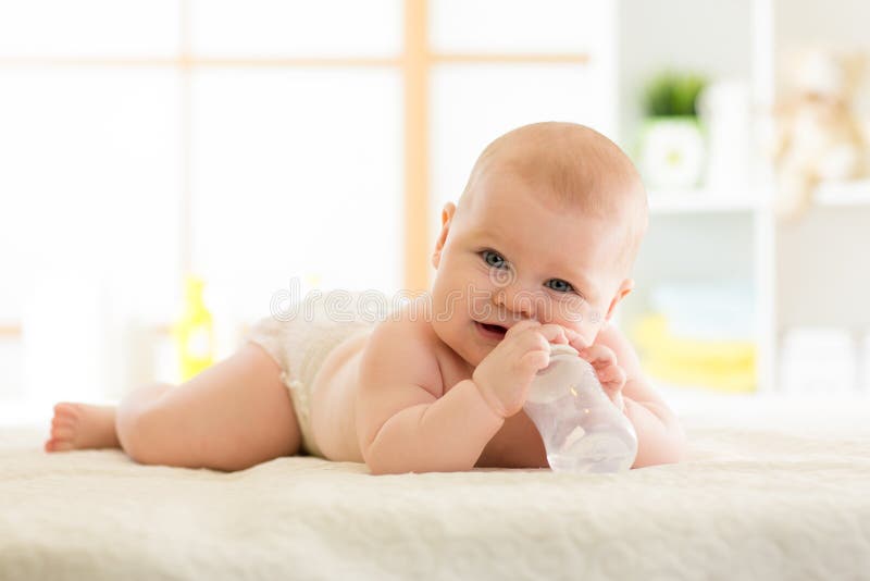 Leuke baby met fles op bed stock foto. Image of fles - 89397282