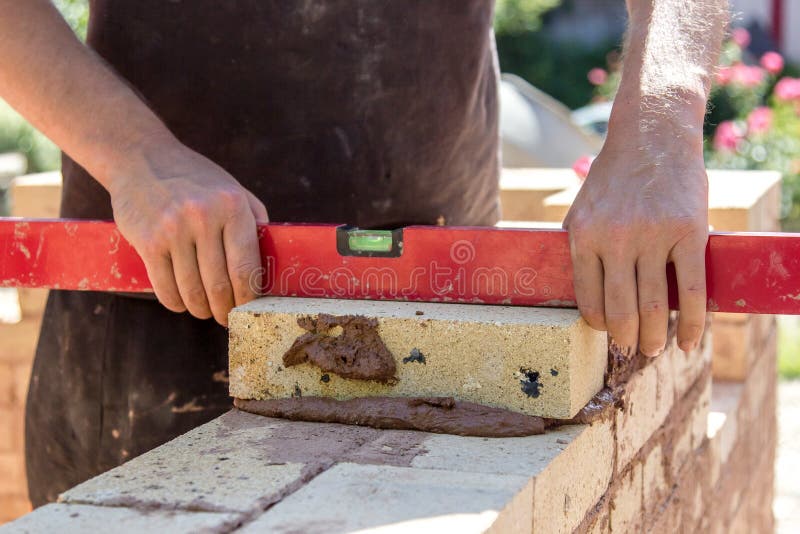 Leveling a brick stock photo. Image of shirt, tool, brown - 41536836