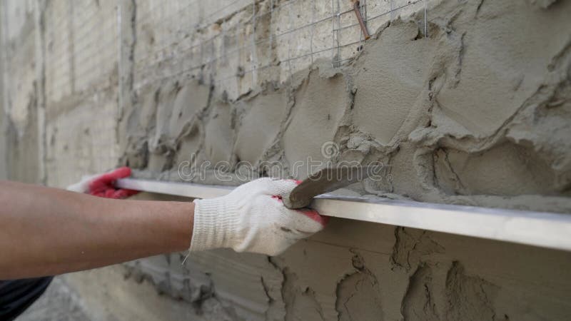 Applying and Leveling the Wall Using Construction Tools. Leveling the ...
