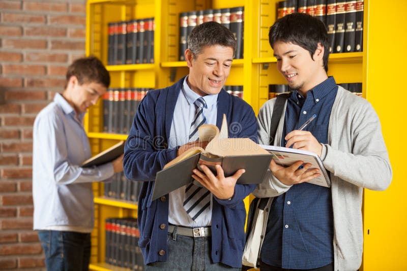 Librarian Assisting Student in College Library Stock Photo - Image of ...
