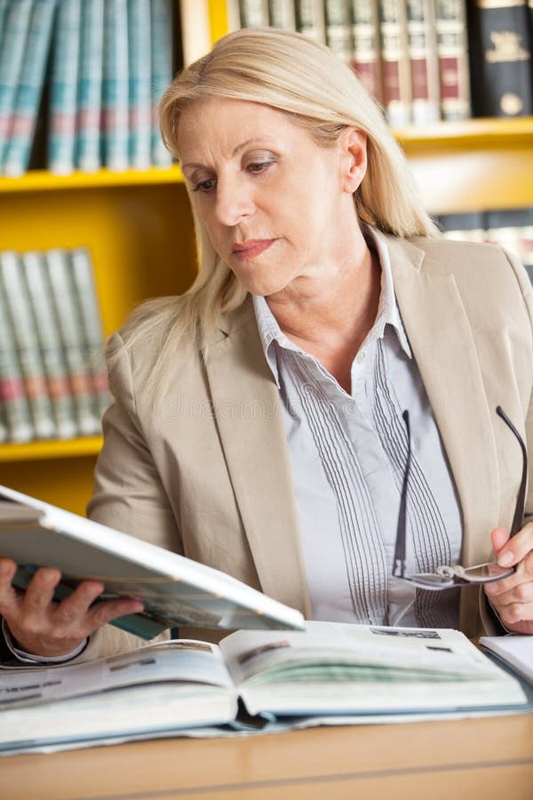 Librarian Reading Book at Table in Library Stock Photo - Image of girl ...