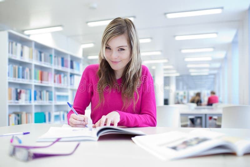 Young Student Girl Concentrated Studying for Exam at College Library ...