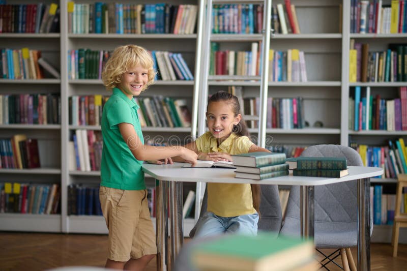 Classmates Reading Together in a School Library Stock Photo - Image of ...