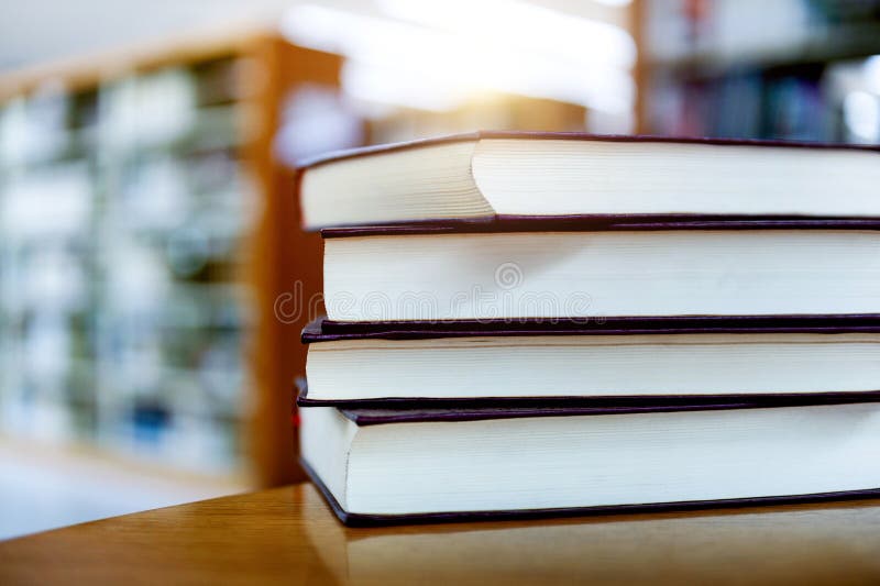 Four books stacked on desk stock photo. Image of bookcase - 284877872