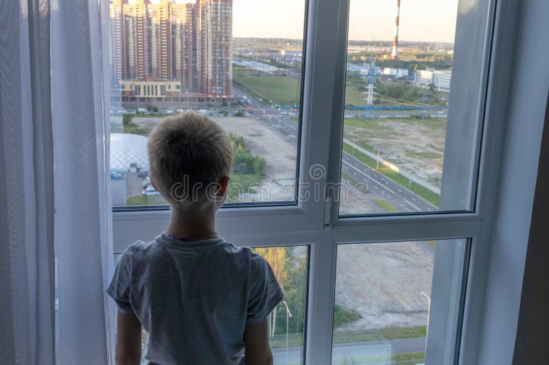 Life in City. Boy Looks Out Window at City, Thinking about Future Stock ...