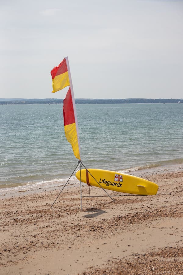 A Life Guard Warning Flag and Surfboard on a Beach Editorial Stock ...