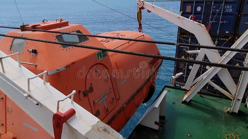 Orange Lifeboat Secured on a Ferry Deck Over Calm Waters, Ready for ...