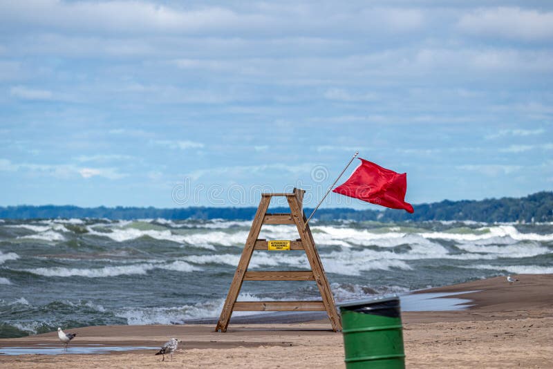 A Lifeguard Chair on the Beach with a Red Warning Flag Flying in the ...