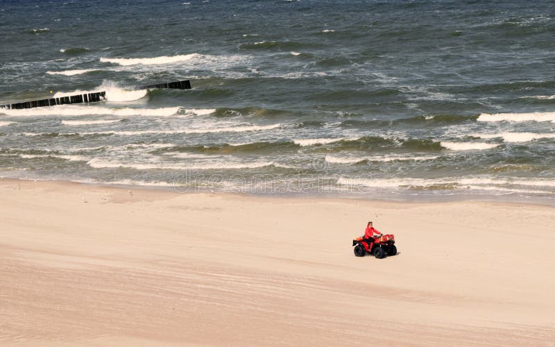 Lifeguard Patrolling the Baltic Beach on a Quad Bike Stock Image ...