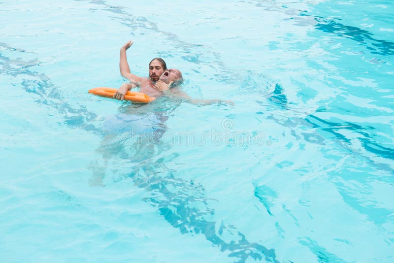 Lifeguard Rescuing Senior Man from Swimming Pool Stock Image - Image of ...