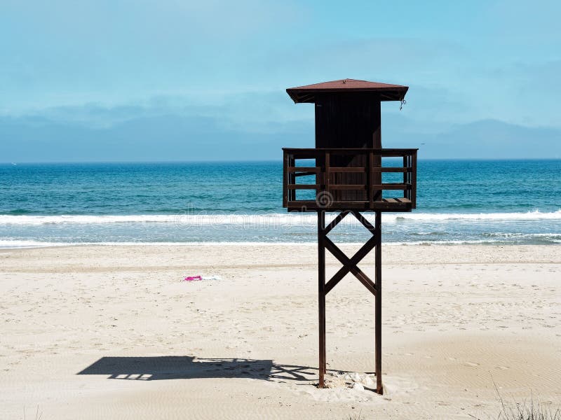 Lifeguard Tower on an Empty Beach with a Blue Sky and Calm Ocean Waves ...