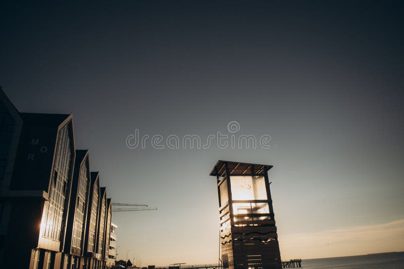 A Lifeguard Tower is in Front of a Row of Beach Huts Stock Image ...